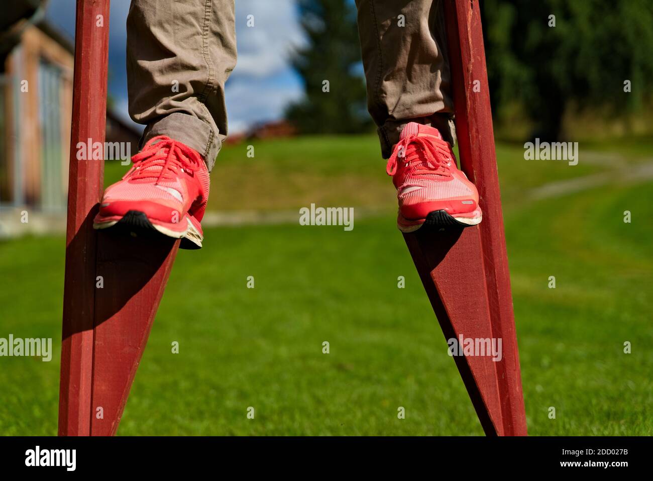 Person walking on traditional stilts in a park Stock Photo - Alamy