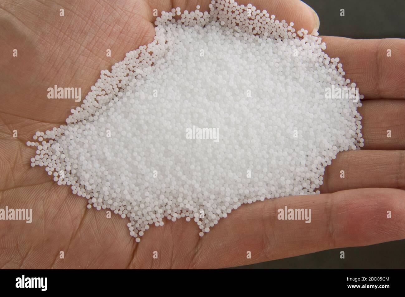 Hand holding white polystyrene foam beads ball drop Stock Photo - Alamy