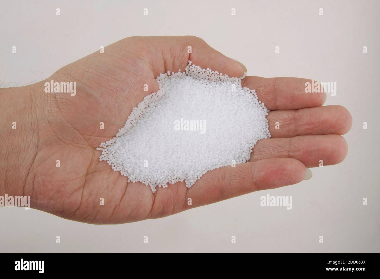 Hand holding white polystyrene foam beads ball drop Stock Photo - Alamy