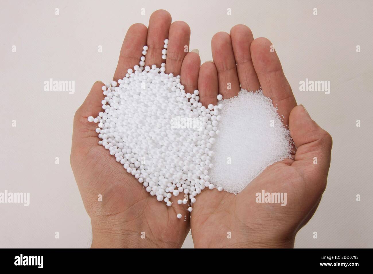 Hand holding white polystyrene foam beads ball drop Stock Photo - Alamy