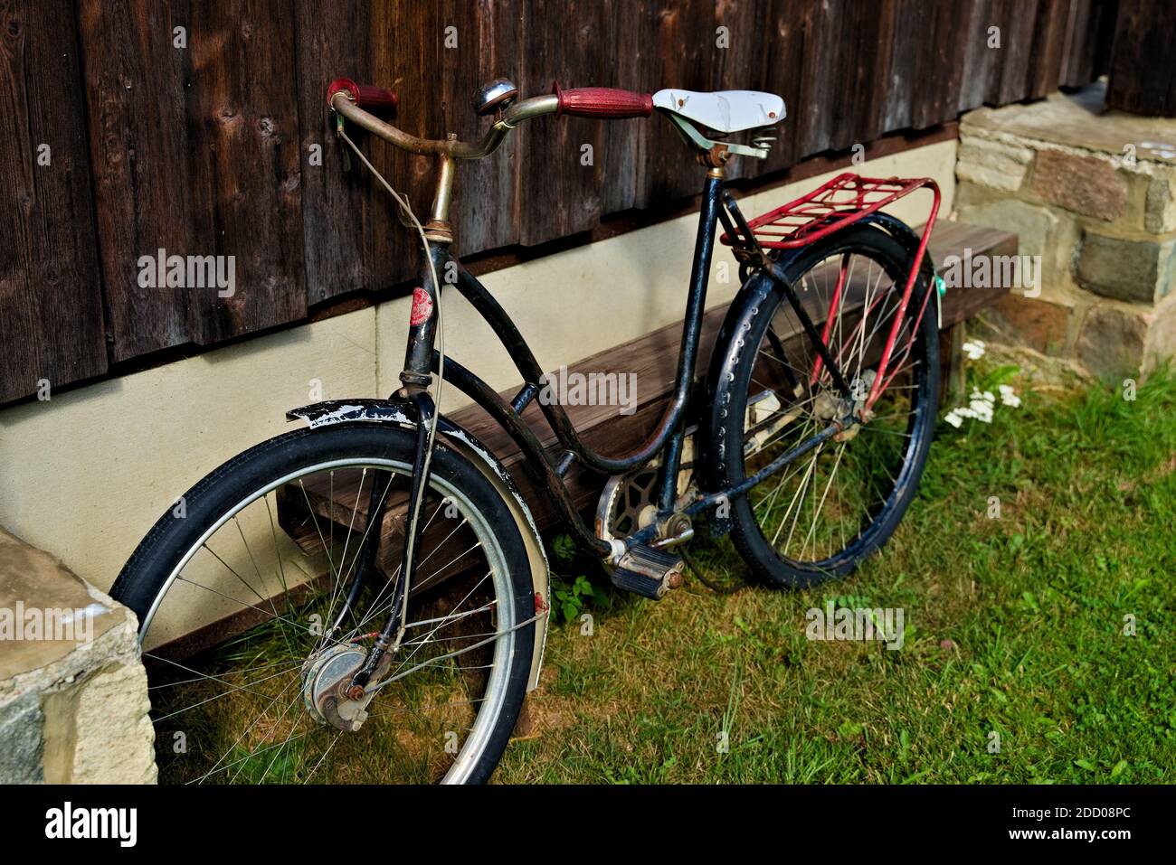 Old vintage bicycle clearly worn and rusty parked by a brown timber ...
