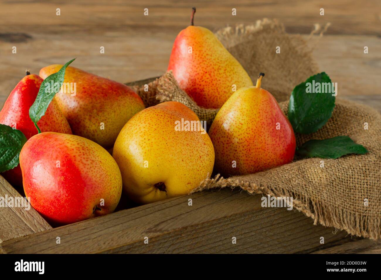 ripe red and yellow pears in a wooden box close-up. background with ...