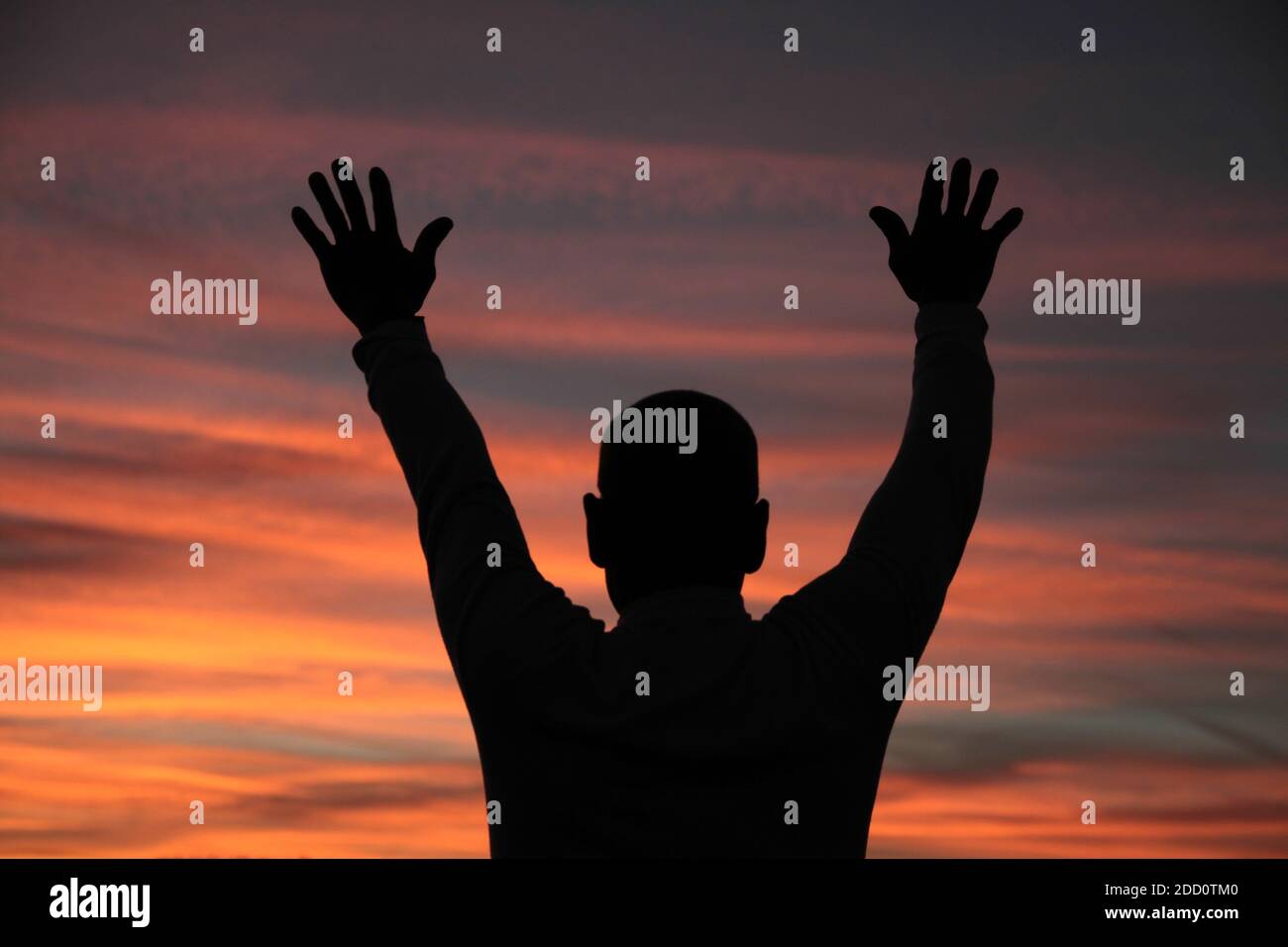 man praying to god with arms outstretched in the sky sunset stock photo ...