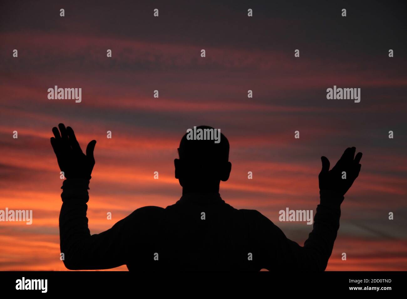 man praying to god with arms outstretched in the sky sunset stock photo ...
