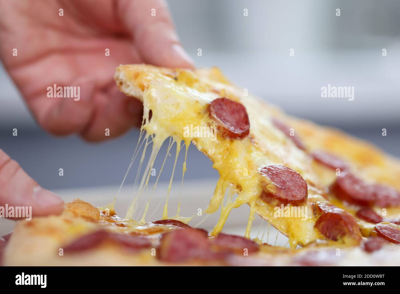 Man's hand holds a slice of pizza Stock Photo - Alamy