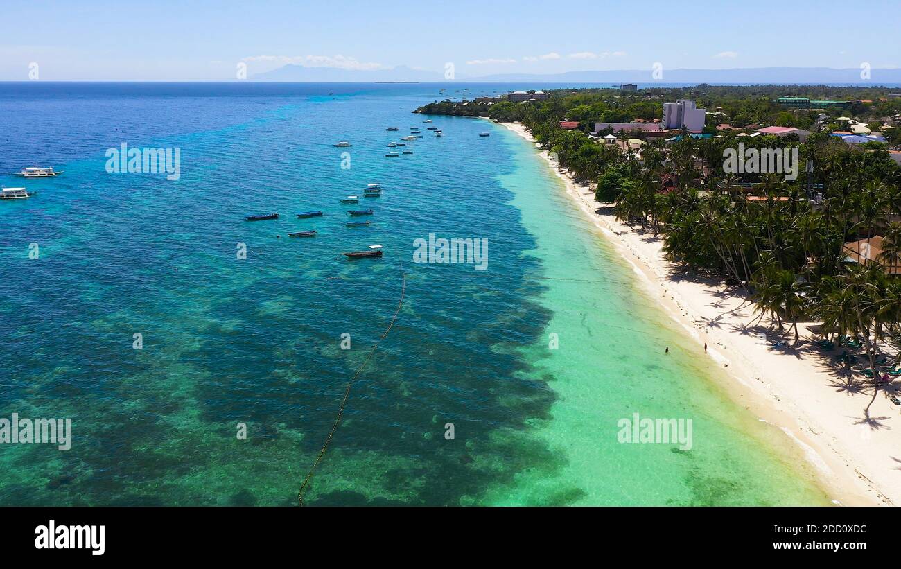 Tropical sandy beach with palm trees and turquoise clear waters. Alona ...