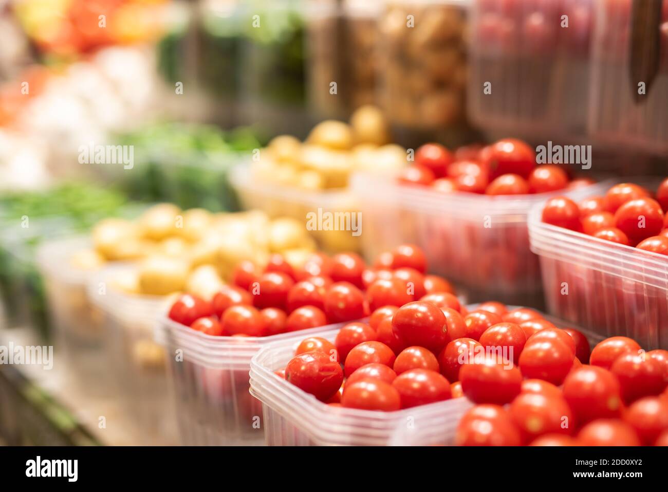 Small tomatoes in baskets on street market, closeup with blurred ...