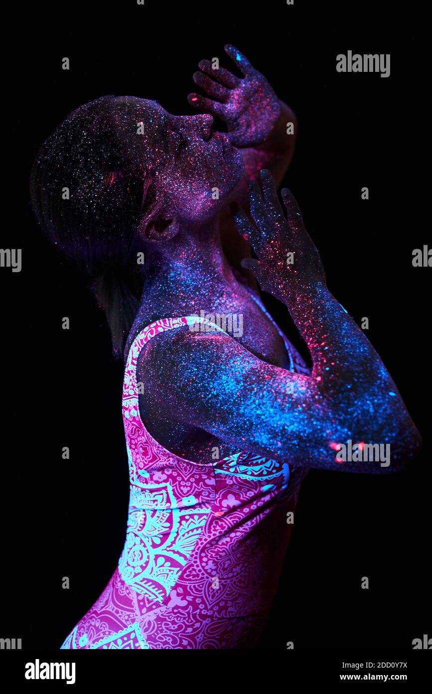 Art woman cosmos in ultraviolet light. Entire body is covered with ...