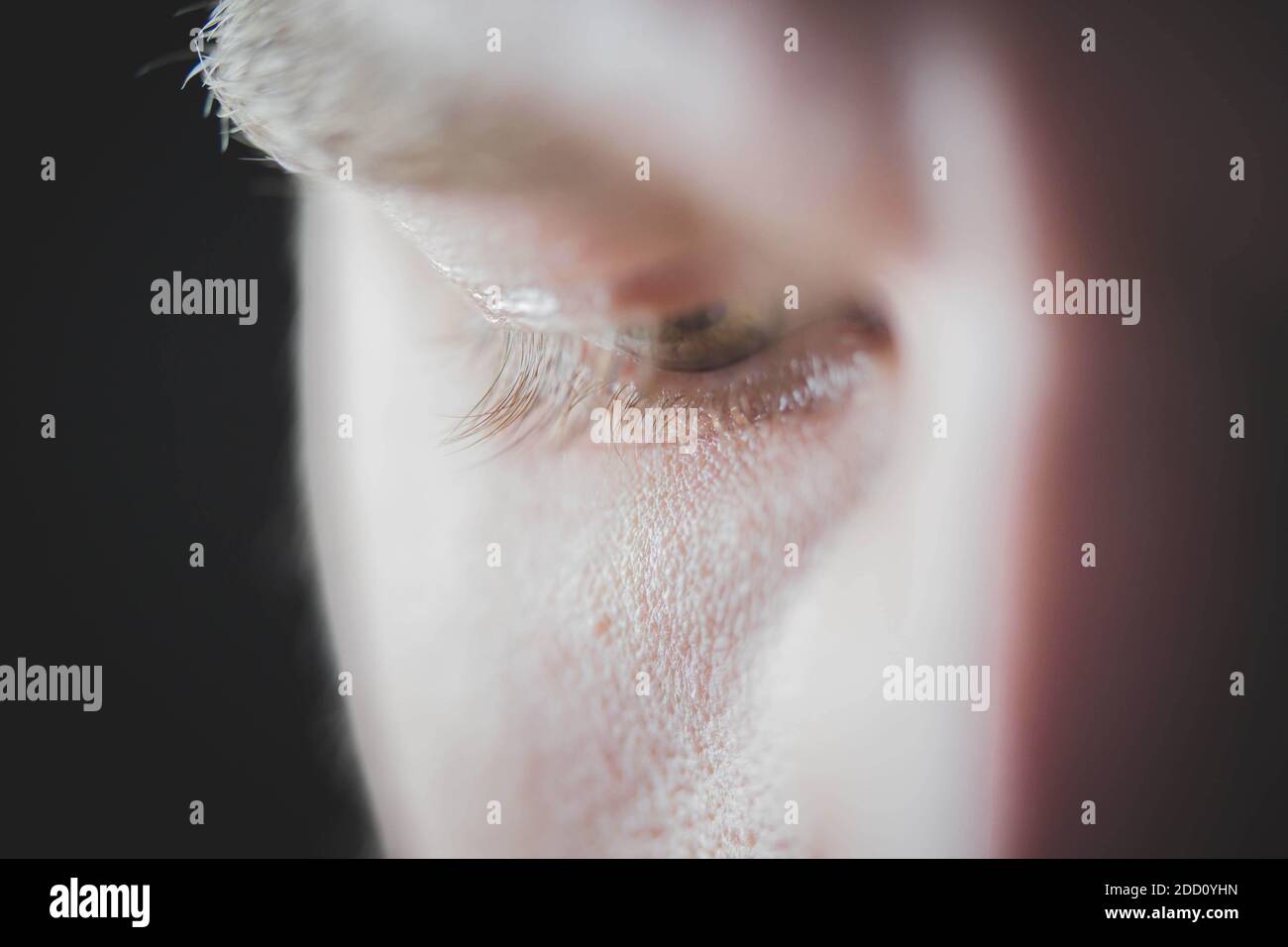 A selective focus closeup of a male's eye looking down - concept of ...