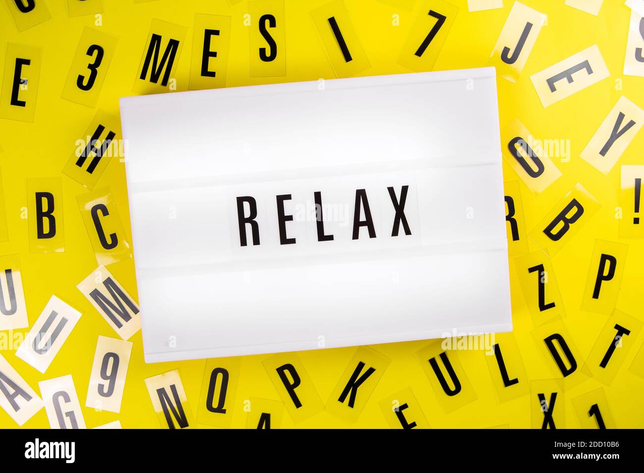 Relax word on lightbox on background of scattered plastic alphabet ...