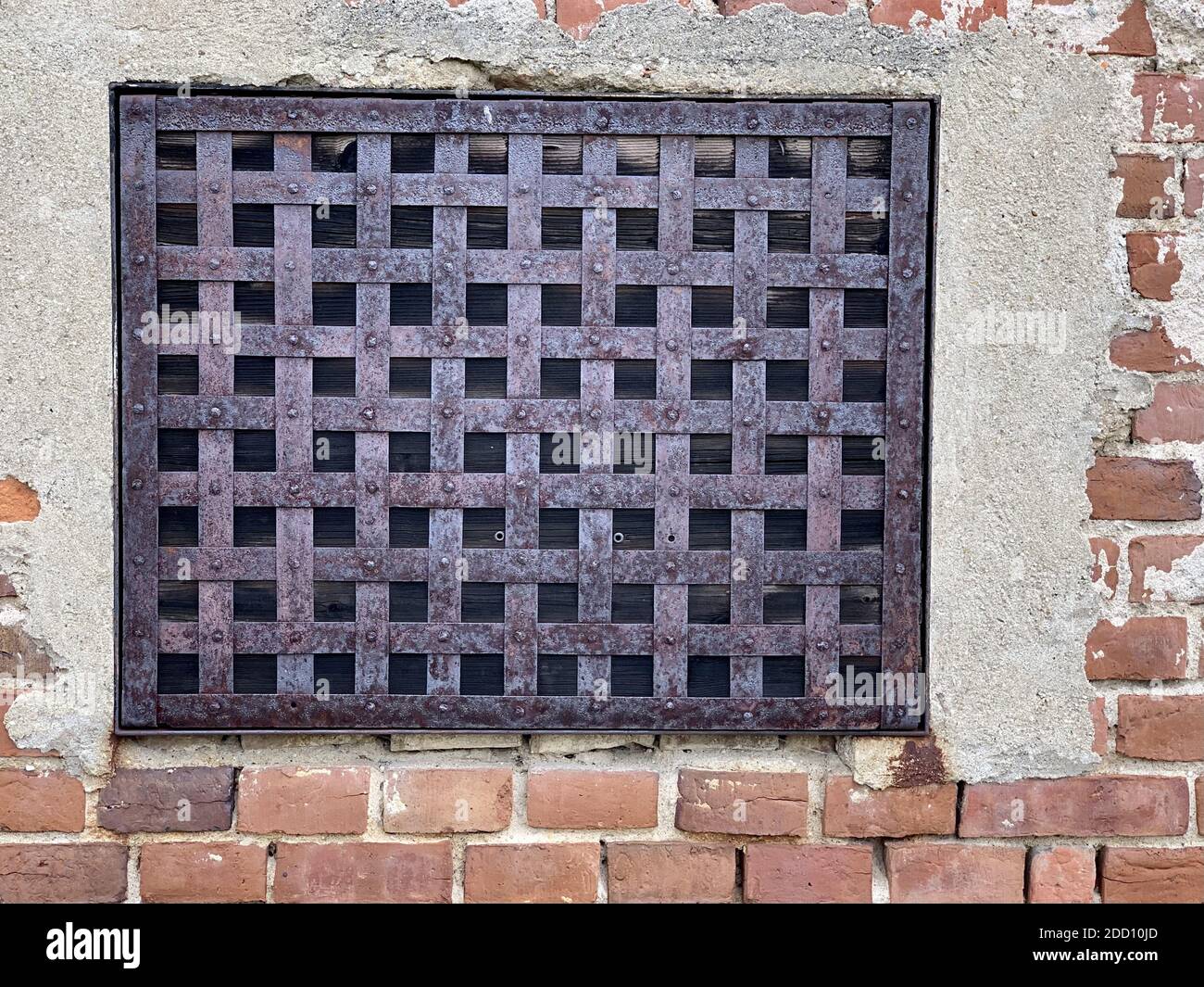 A top view closeup of a storm drain surrounded by bricks covered in ...
