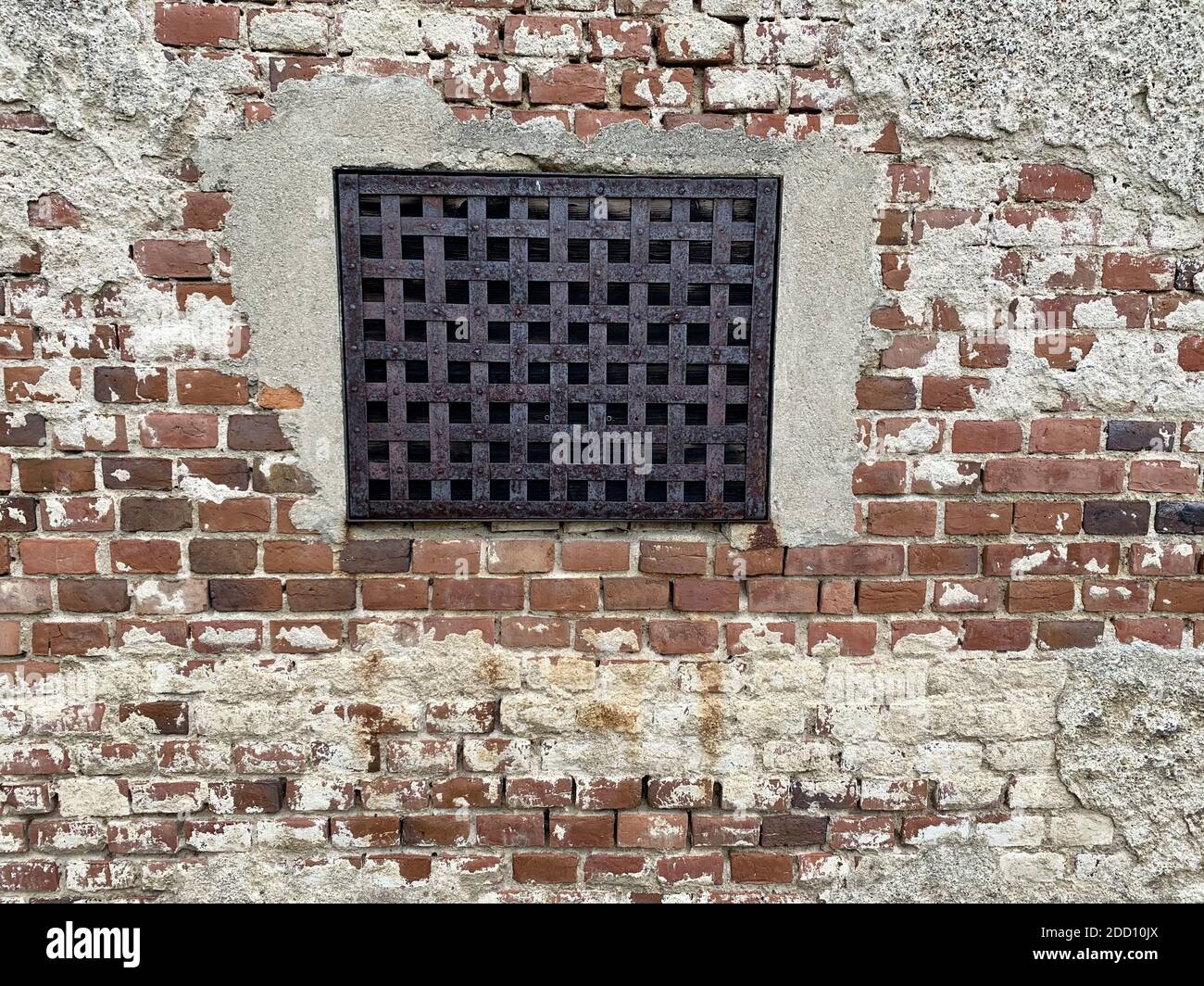 A top view closeup of a storm drain surrounded by bricks covered in ...