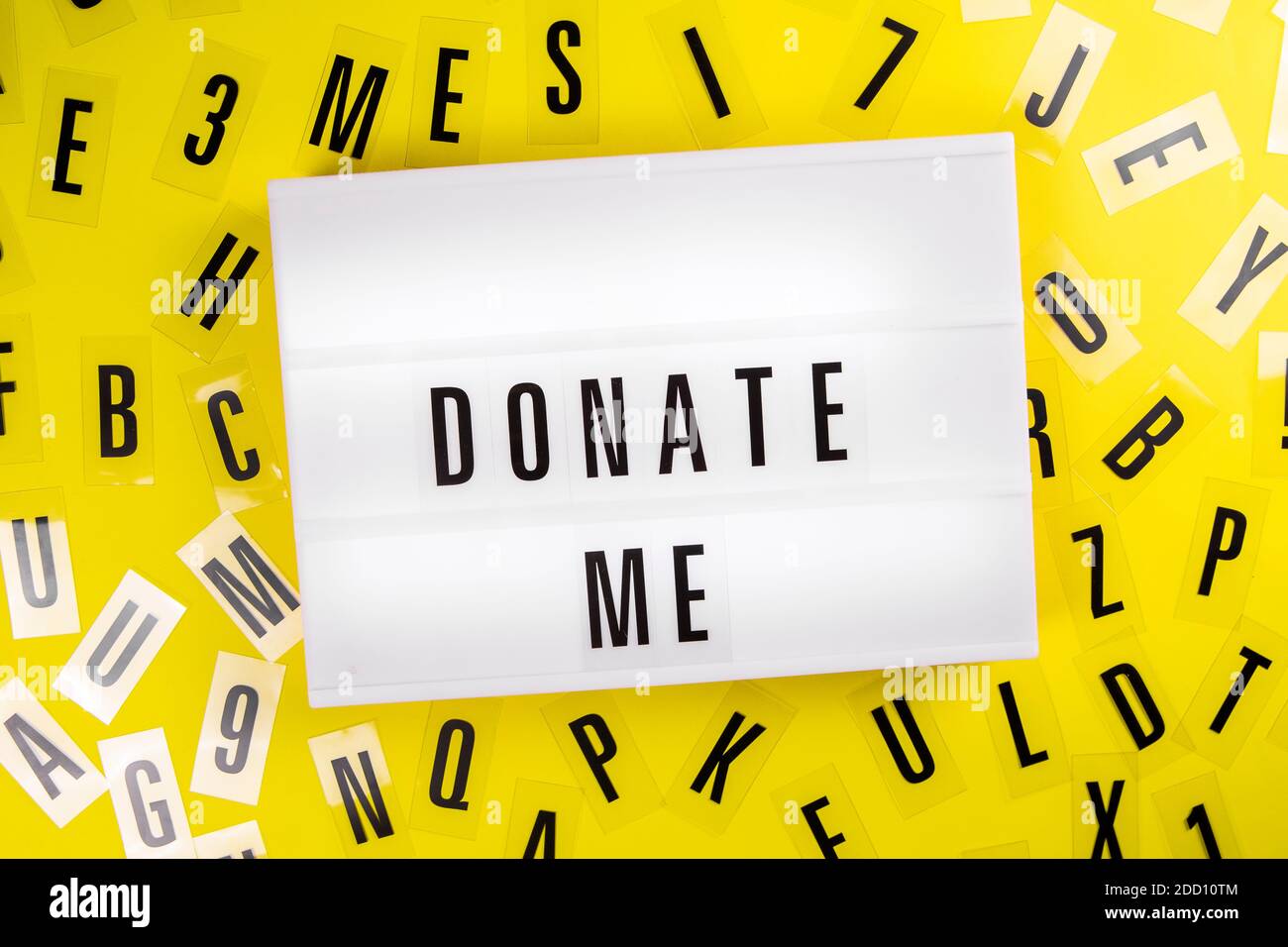 Donate Me text on lightbox on scattered letters background of plastic ...