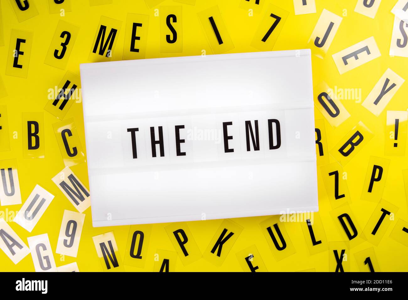 The End message on lightbox on scattered letters background of plastic ...