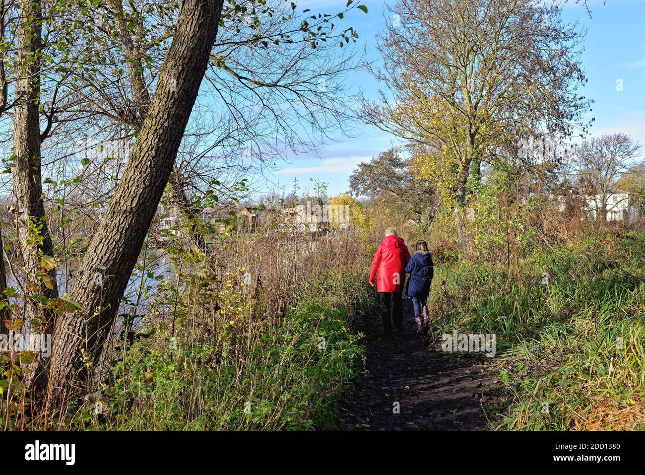 Elderly woman and teenager girl walking on the towpath by River Thames ...