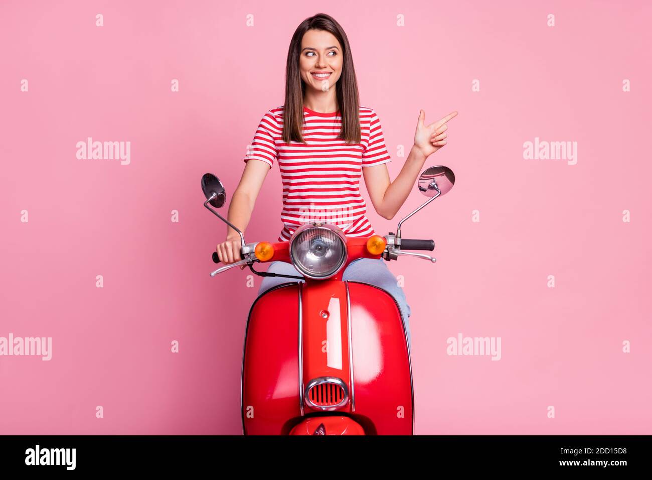 Photo portrait of curious girl sitting on red motorcycle pointing at ...