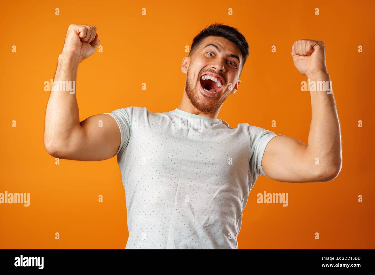 Portrait of excited, successful man raising hands up Stock Photo - Alamy