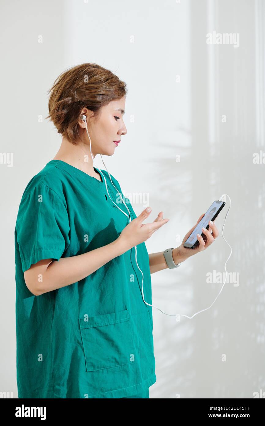 Surgeon calling coworker Stock Photo - Alamy