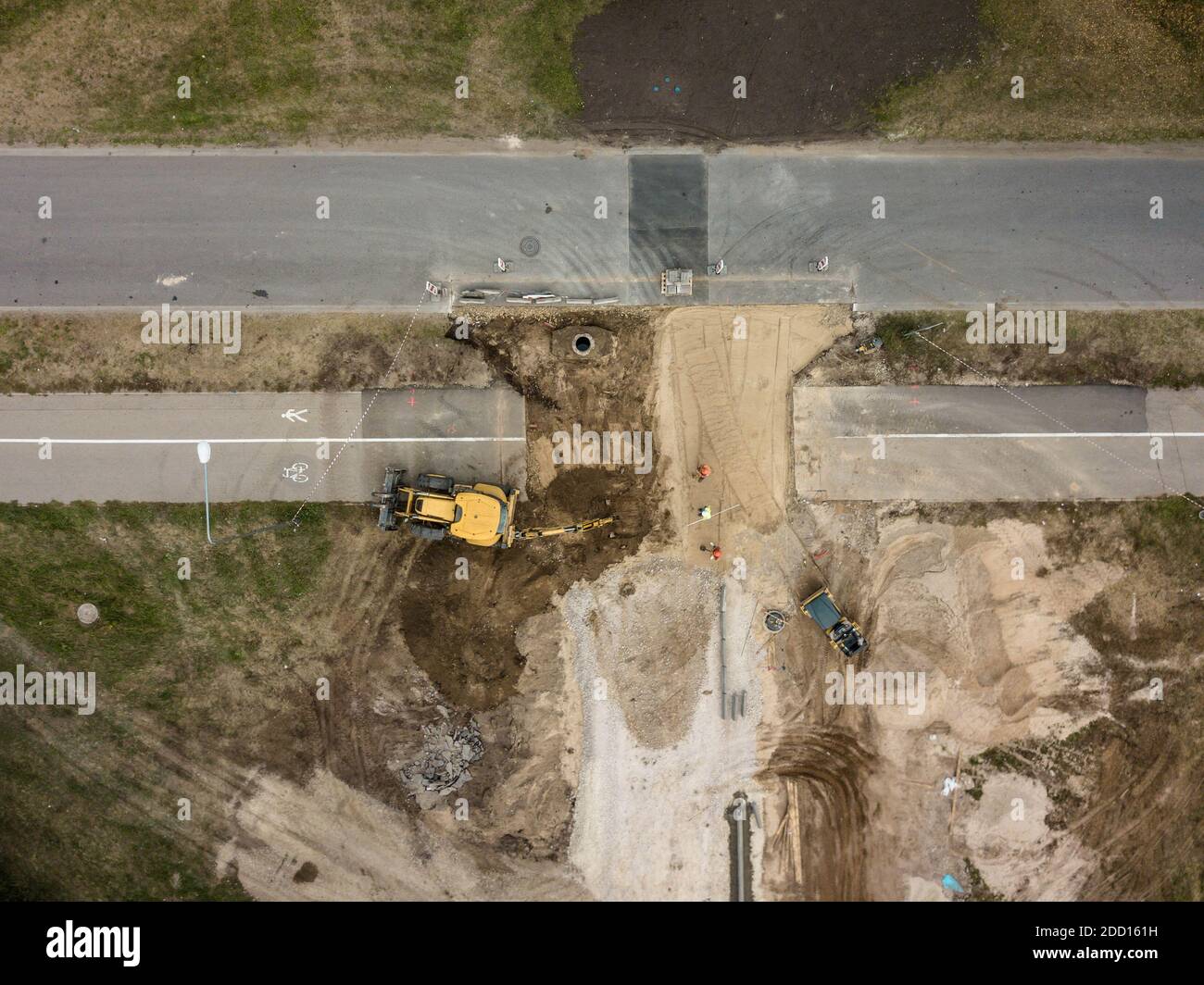 Aerial view from above of road construction works. Yellow digger and ...