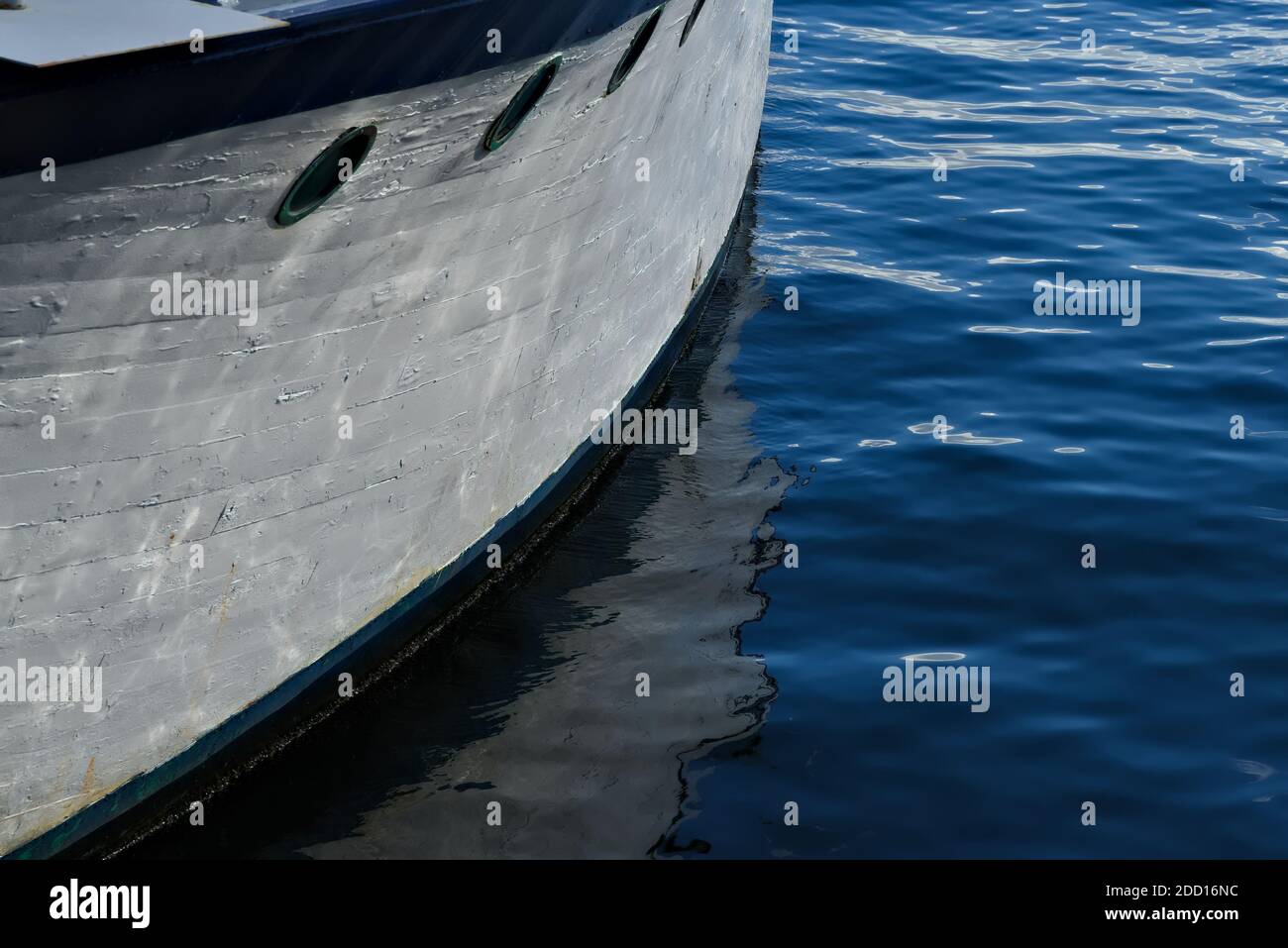 Portholes in the side of a white wooden tall ship sitting in the port ...