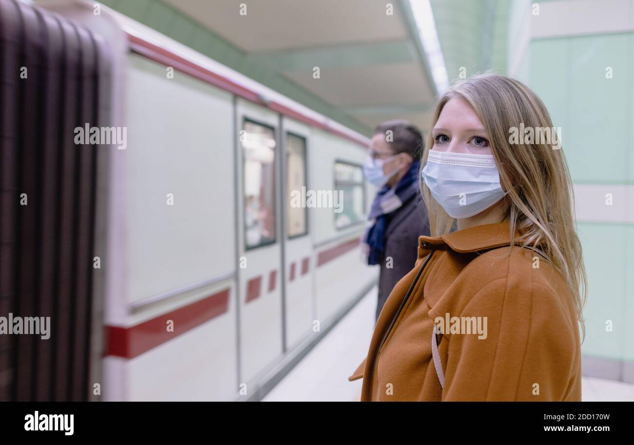 People in public transport wearing mask while train arrives Stock Photo ...
