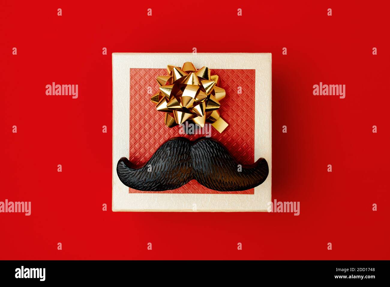 flat lay with present box and mustache on red background Stock Photo ...