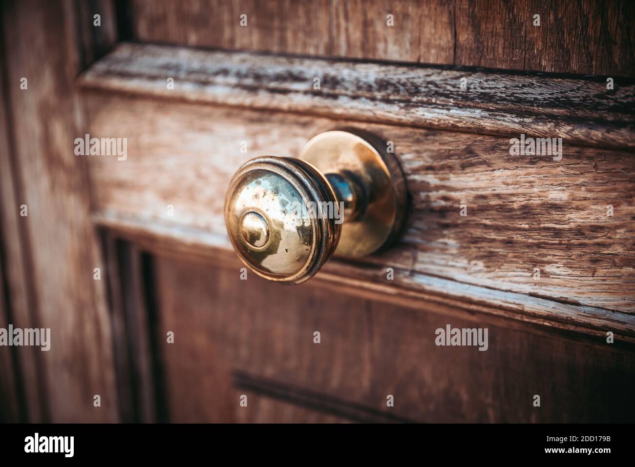 A closeup of an old corroded metal doorknob on a dark wooden door Stock ...