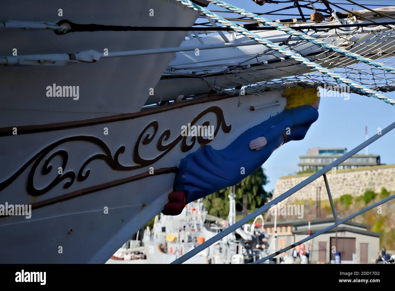 Blue female figurehead on the bow of an old tall ship by the docks ...