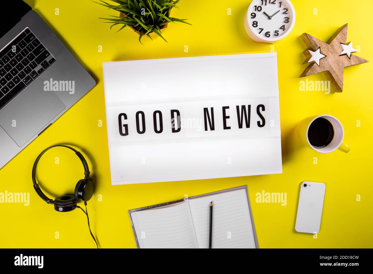 Good News message on lightbox on modern yellow office desktop with ...