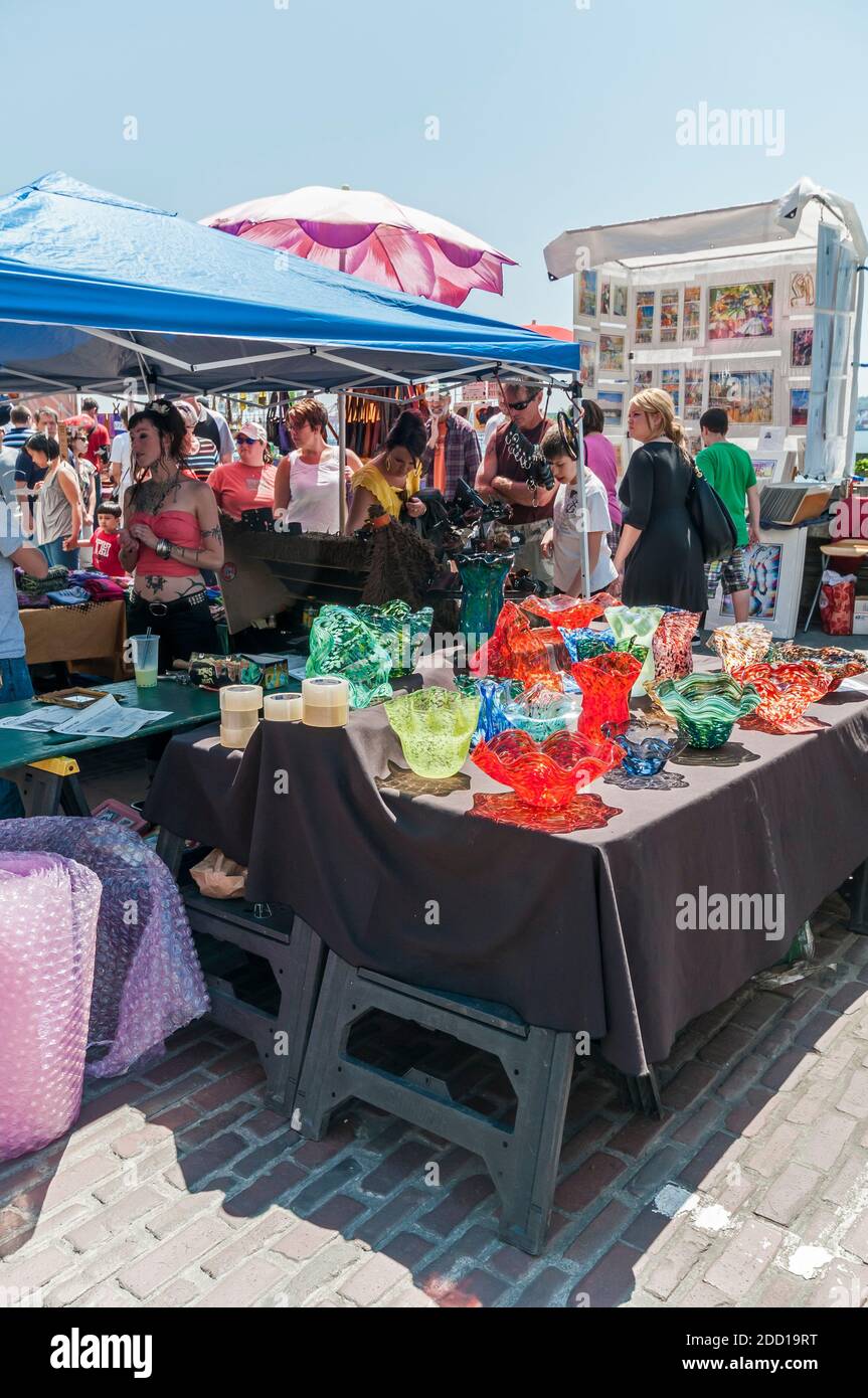 A sales kiosk, a tattooed Goth young woman, and people in scene from ...