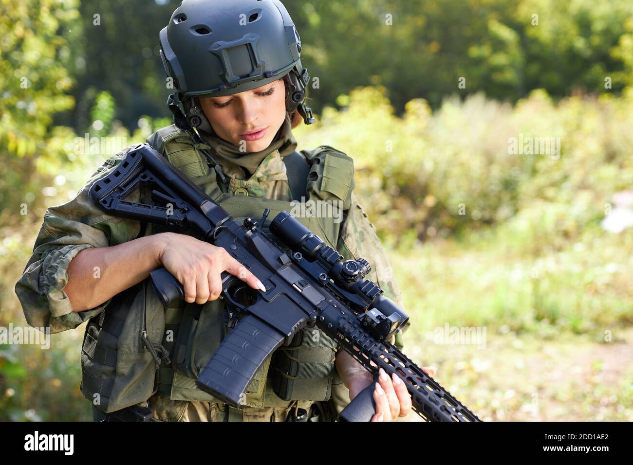 military woman is checking details of weapon before military training ...