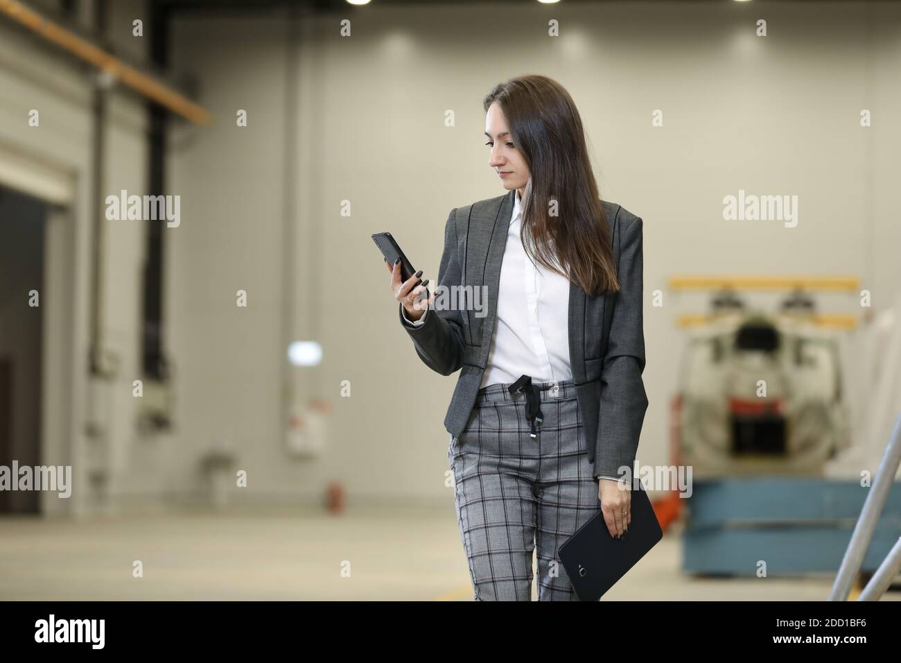 Portrait of a female factory manager in a white hard hat and business ...