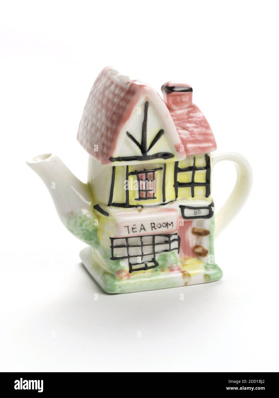 A vertical shot of a house-shaped ceramic teapot isolated on a white ...