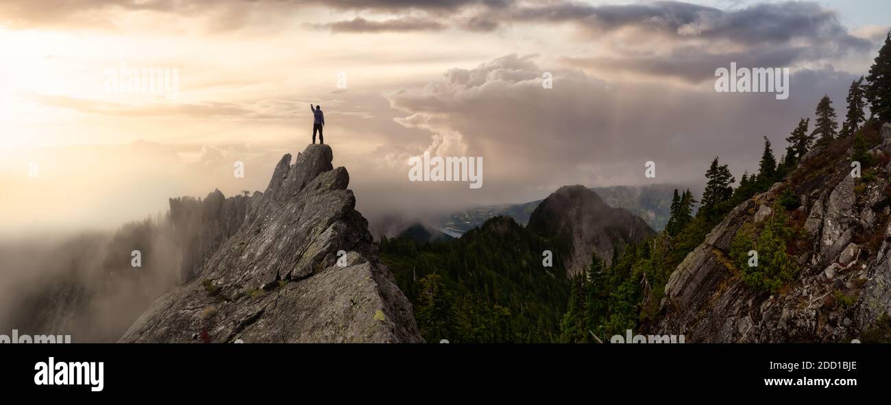 Adventurous Man on top of a rugged rocky mountain Stock Photo - Alamy