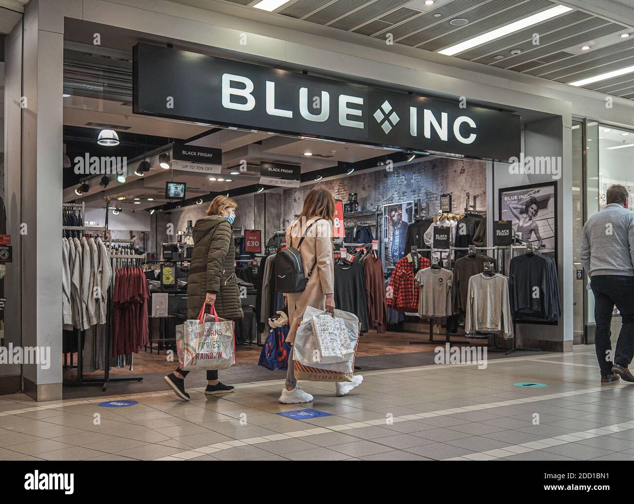 Shoppers wearing face masks walk past a Blue Inc. Store Stock Photo - Alamy