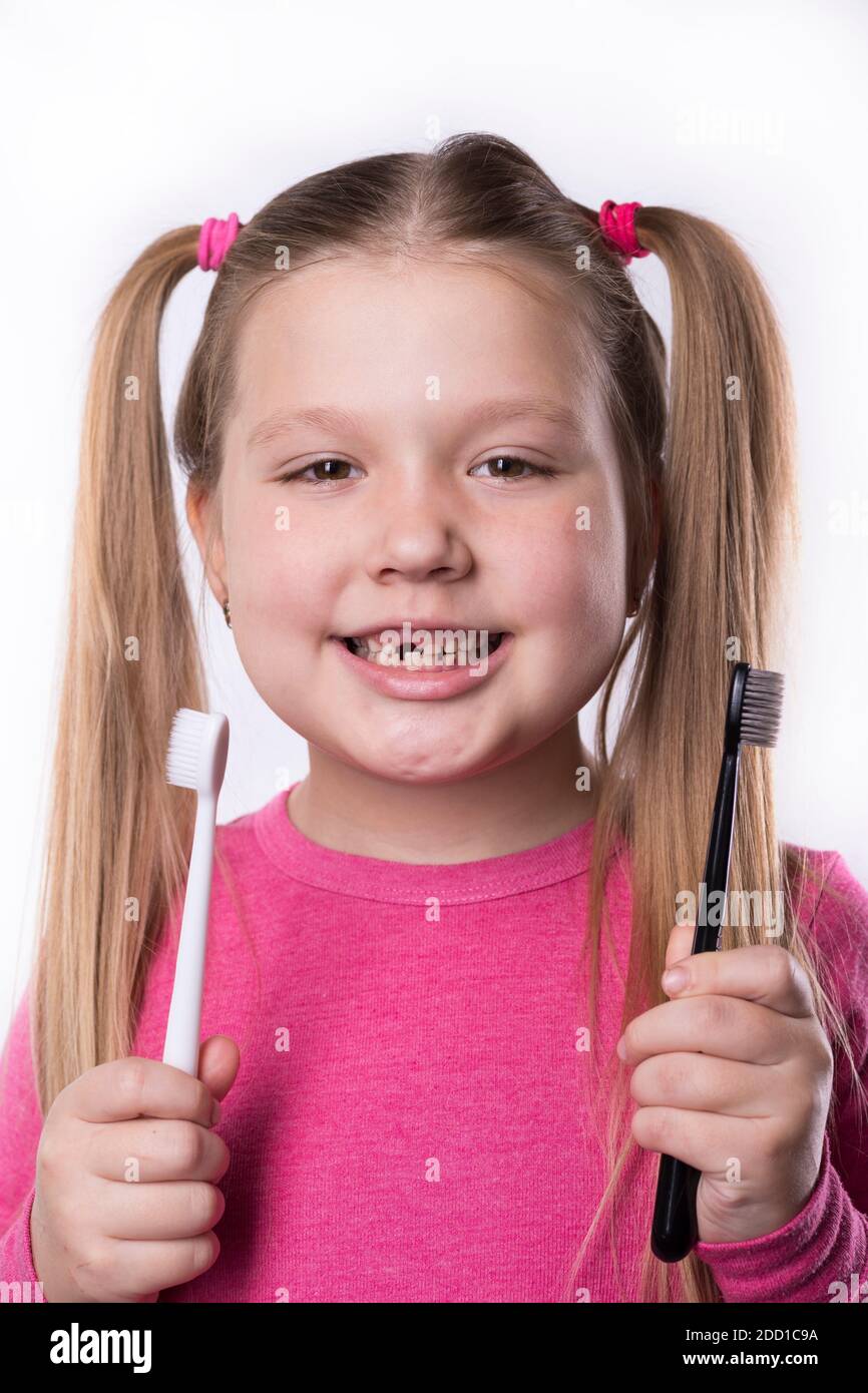 Preschool girl with first adult incisors and a toothbrush. The milk ...