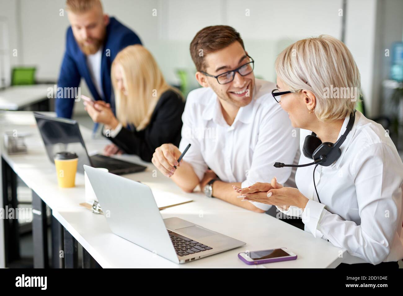 two colleagues sits talking at work, smiling. have fun, happy ...