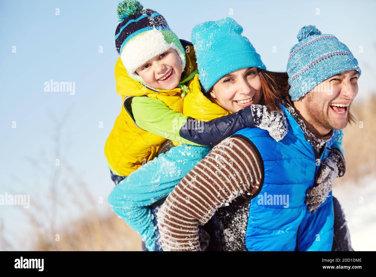 portrait of a happy family in the winter. parents and child outdoors ...