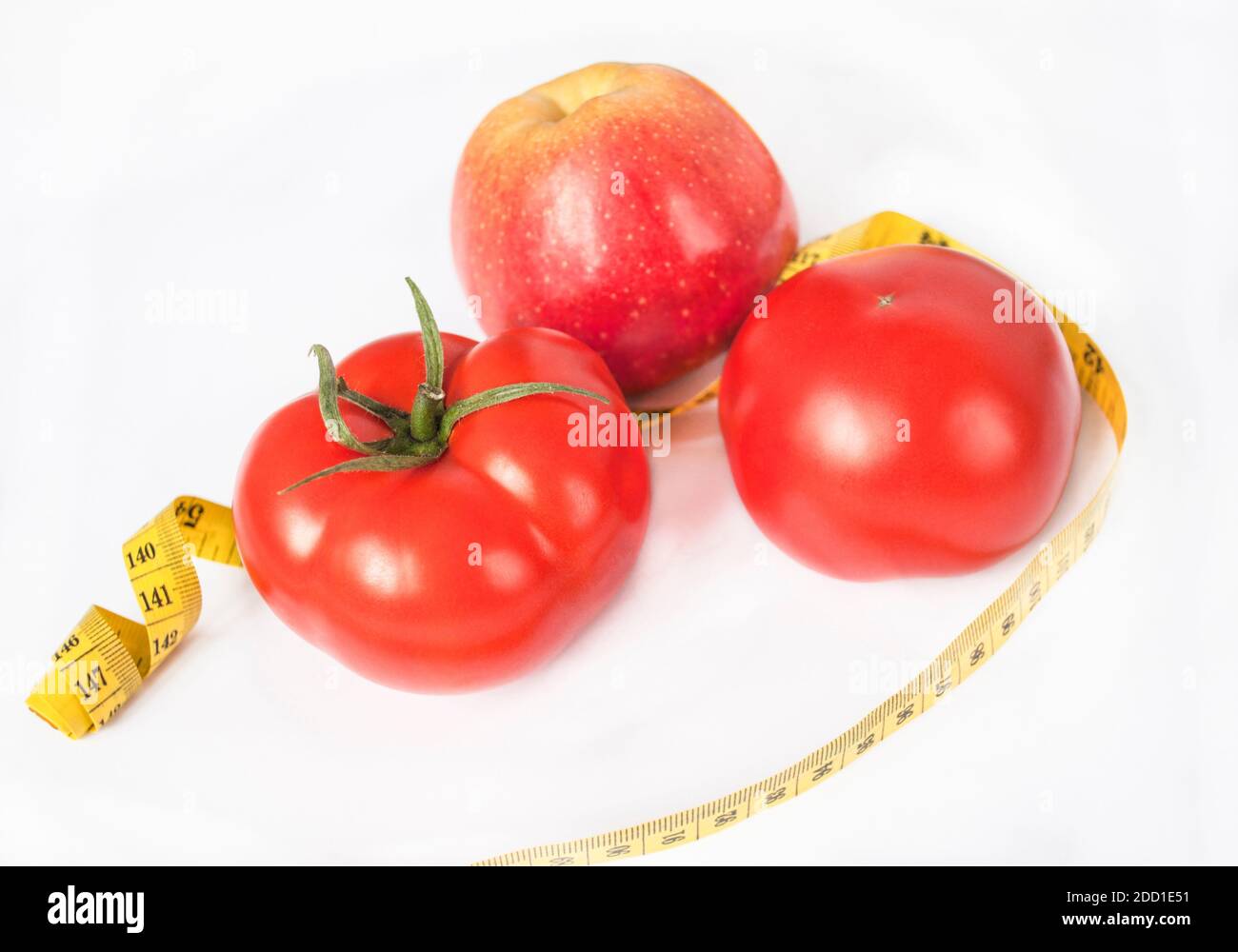 Still life: two tomatoes and an apple, and a centimeter next to them ...