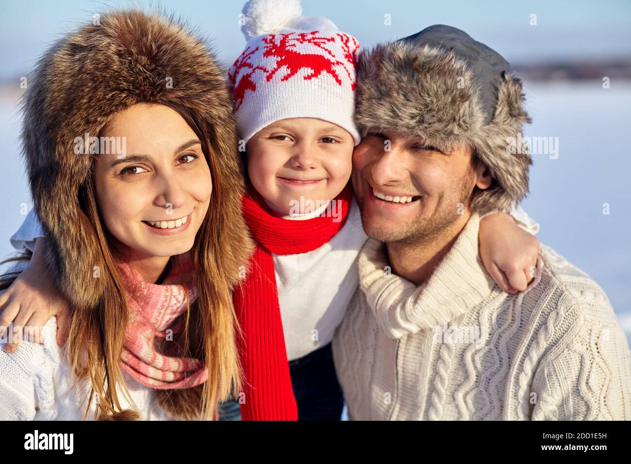 portrait of a happy family in the winter. parents and child outdoors ...