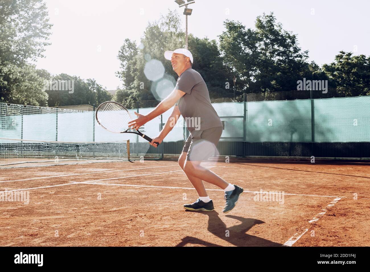 Middle-aged man playing tennis on outdoor tennis filed Stock Photo - Alamy