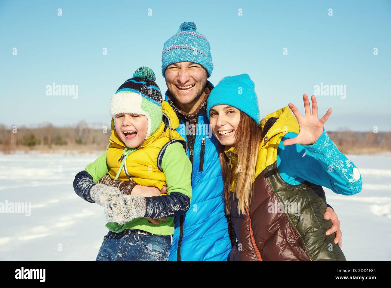 portrait of a happy family in the winter. parents and child outdoors ...