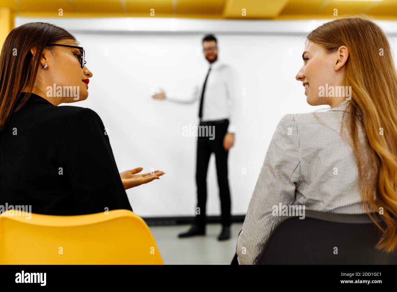 Young business man showing diagram on flyboard to creative team in ...
