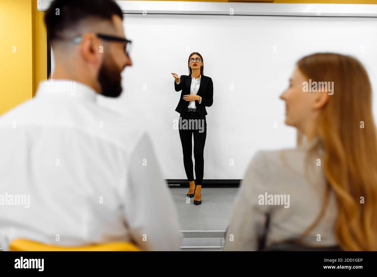 Attractive young business woman making a presentation to her colleagues ...