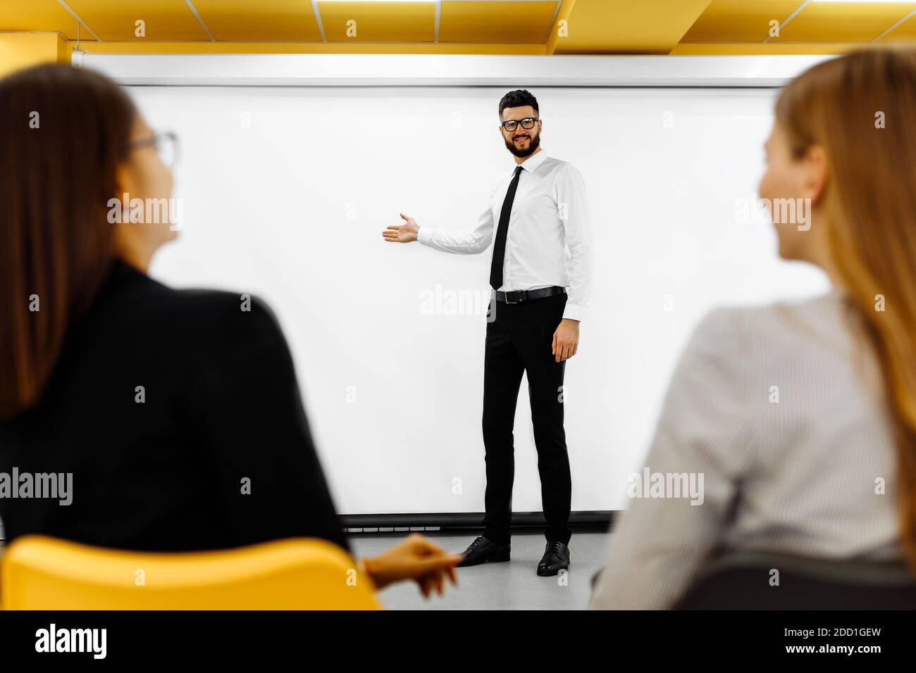 Handsome young businessman making presentation to his colleagues and ...