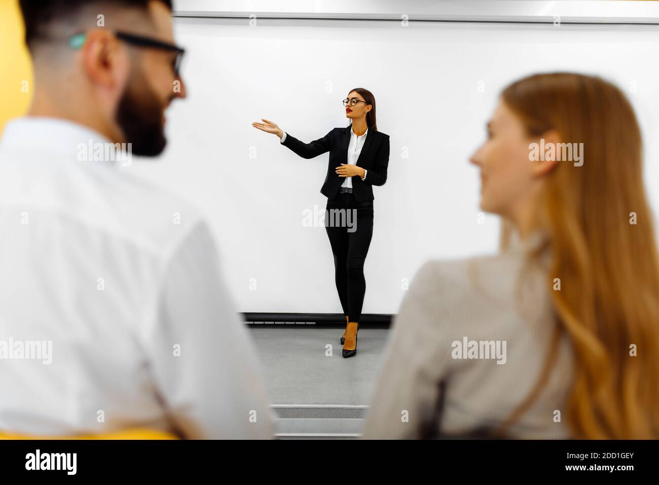 Attractive young business woman making a presentation to her colleagues ...
