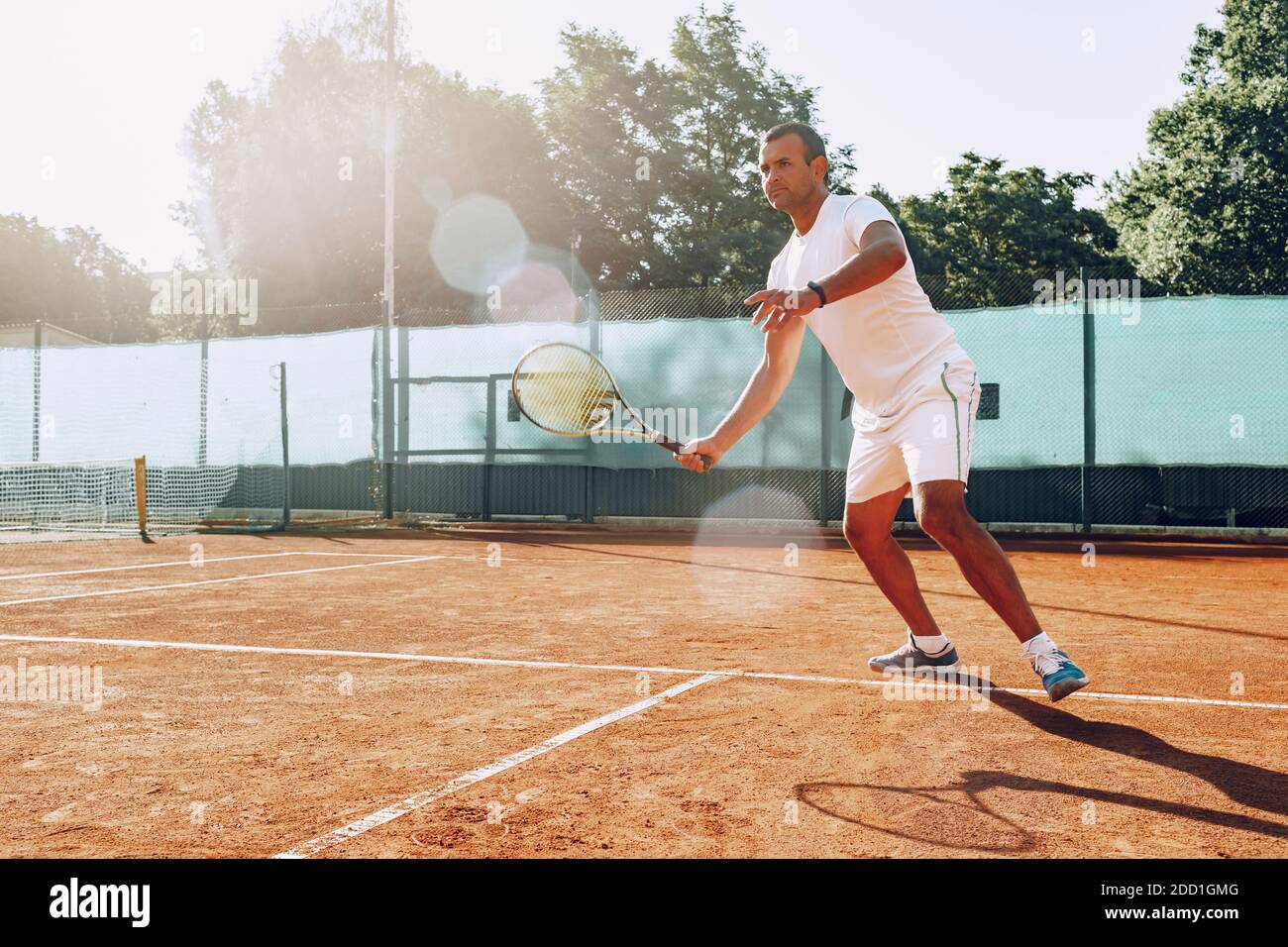 Fit man plays tennis on tennis field Stock Photo - Alamy