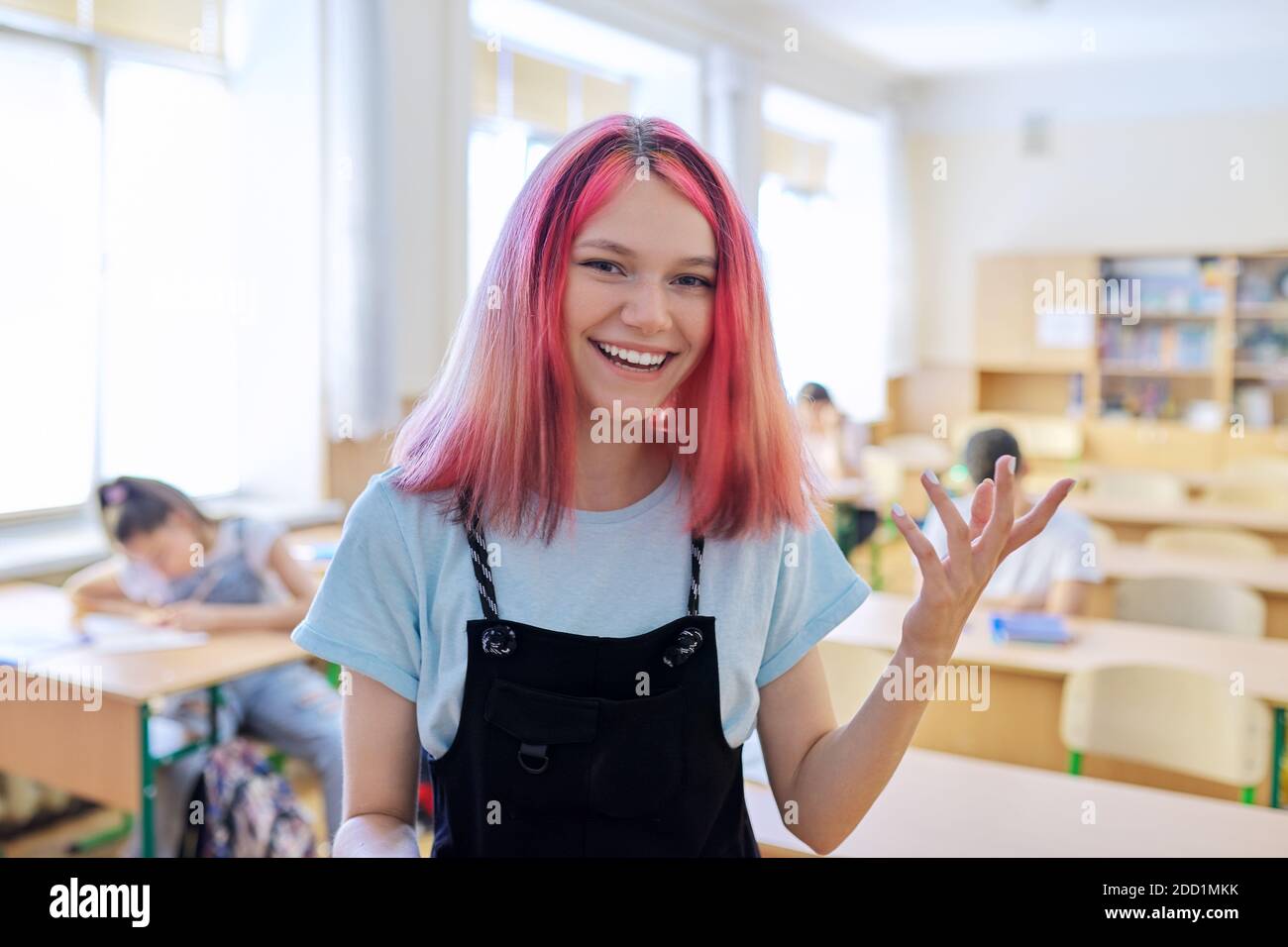 Talking gesturing smiling teenage student at lesson in classroom Stock ...