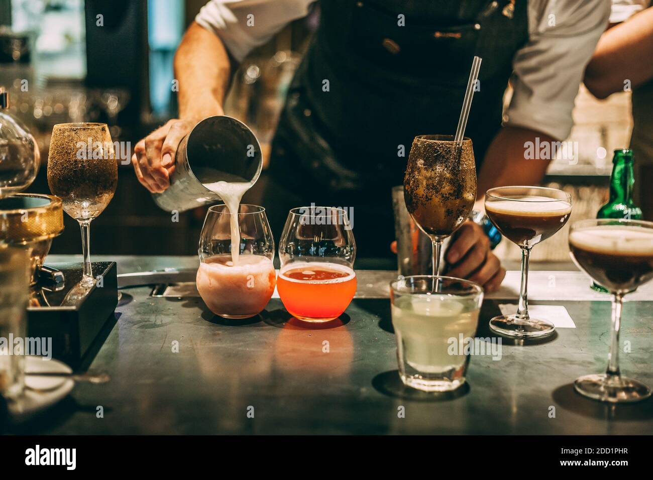 The bartender making an alcoholic cocktail, a summer cocktail in the ...