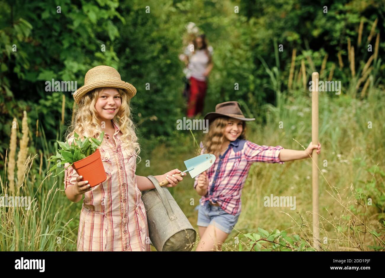 Sisters helping at farm. Eco farming concept. Adorable girls in hats ...